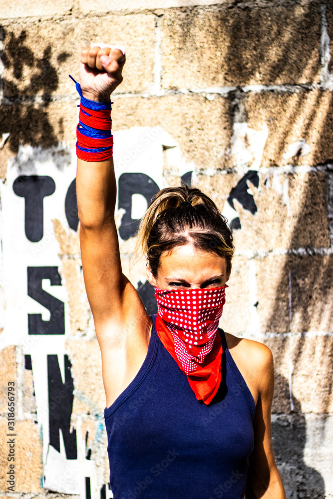 Portrait of young confident woman activist and feminist punching her ...