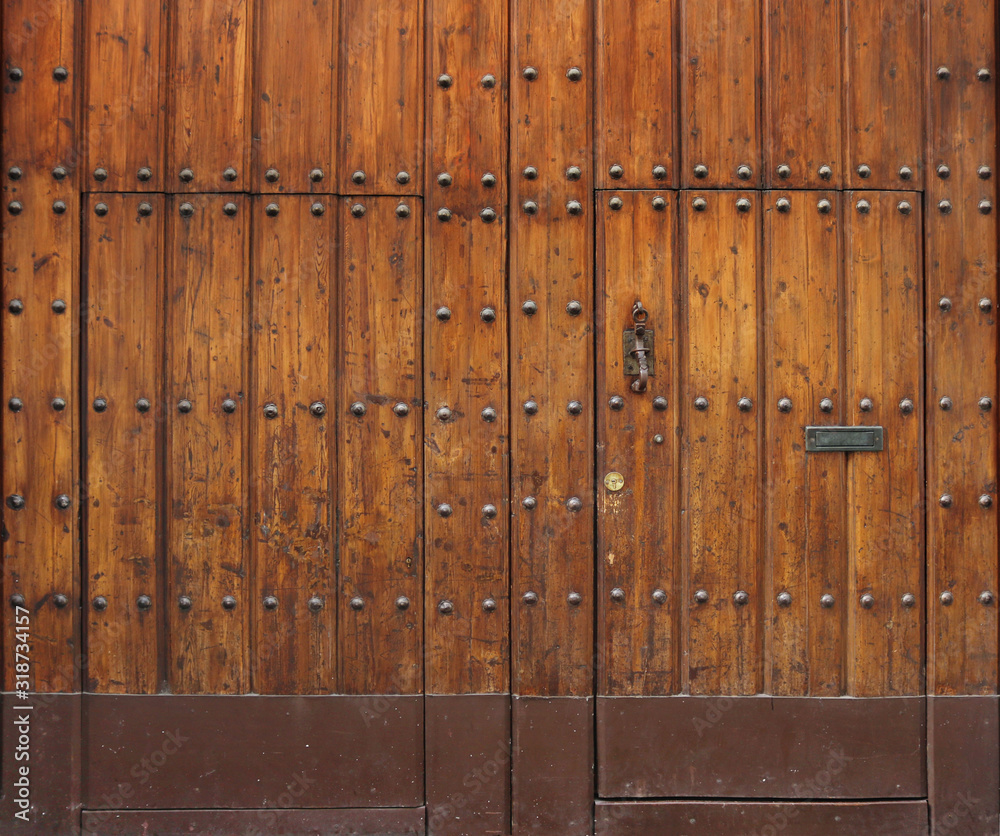 ancient and worn wooden gate with rivets and two small doors Stock ...