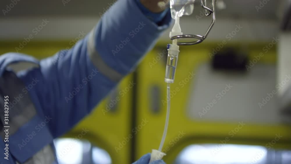 Sequence of shots of male and female paramedics starting intravenous ...