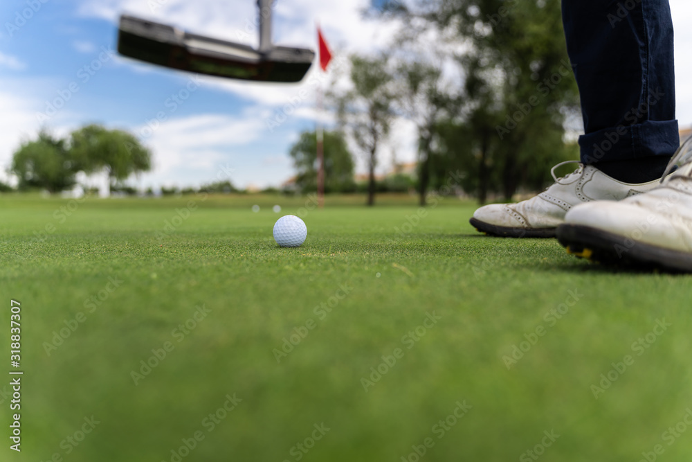 Golf ball and a person's legs on a golf course Stock Photo | Adobe Stock