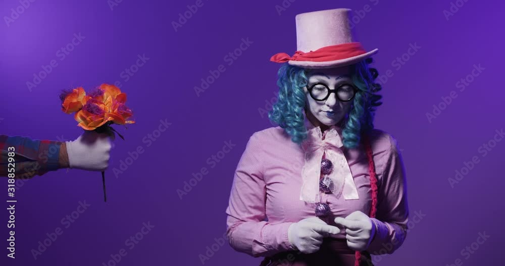 Beautiful funny colorful mime doll receives gift flower from behind the ...