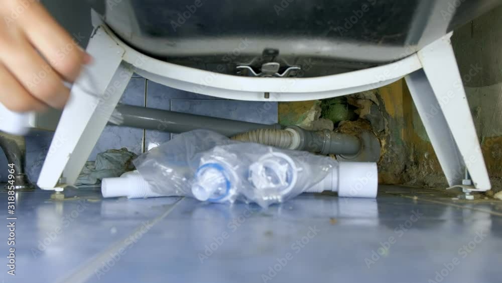 Plumber is fixing problem with clogged plumbing. Unclogging pipe and ...