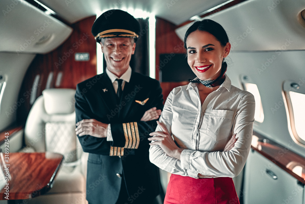 Pilot and flight attendant in private jet Stock Photo | Adobe Stock