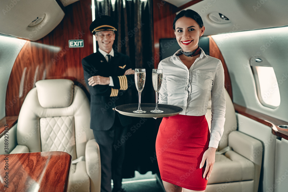 Pilot and flight attendant in private jet Stock Photo | Adobe Stock
