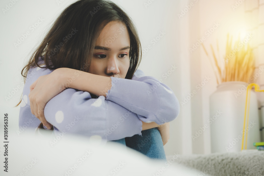 unhappy depressed and worried suffering sad young asian woman sitting ...