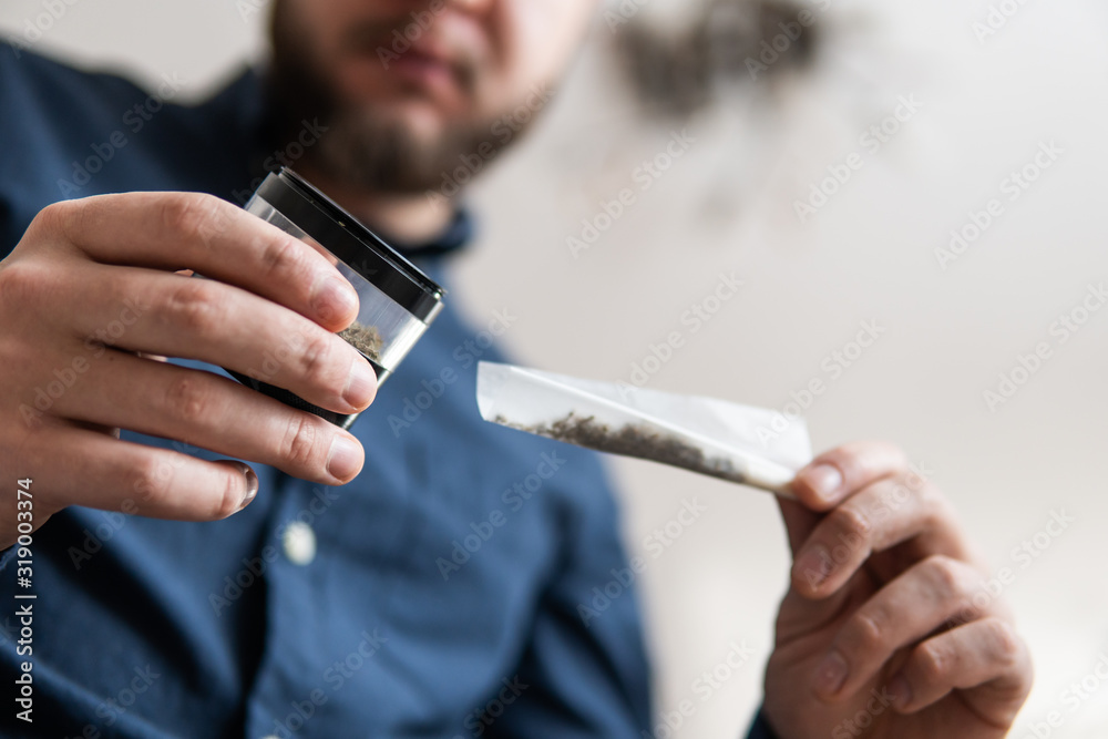 Man rolling a marijuana joint. Man preparing and rolling marijuana ...