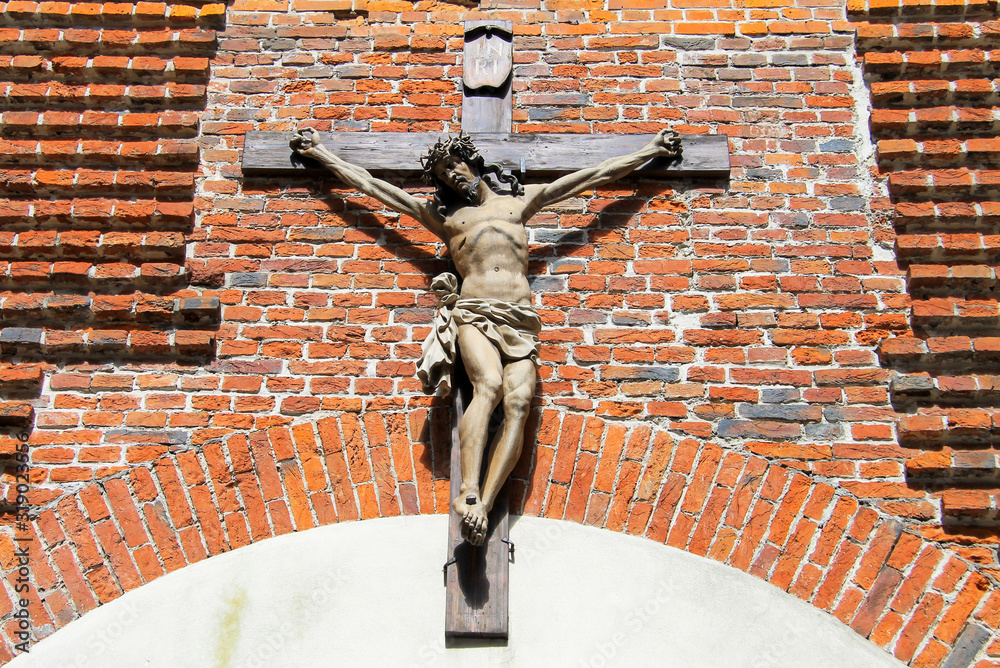 Poster The figure of Jesus Christ crucified on the cross on the wall of an old Christian brick ...