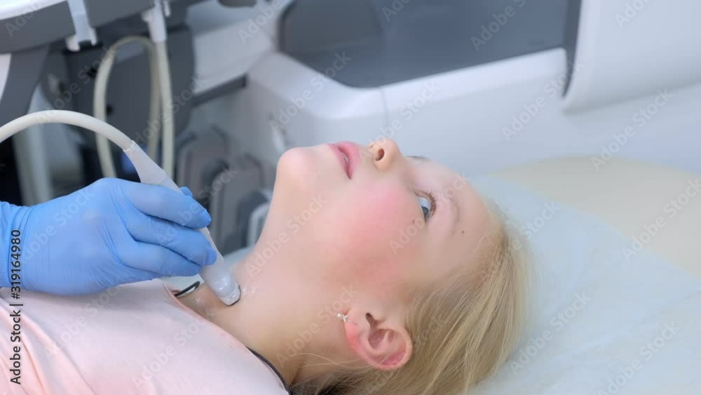Doctor examining patient child girl thyroid gland using ultrasound ...