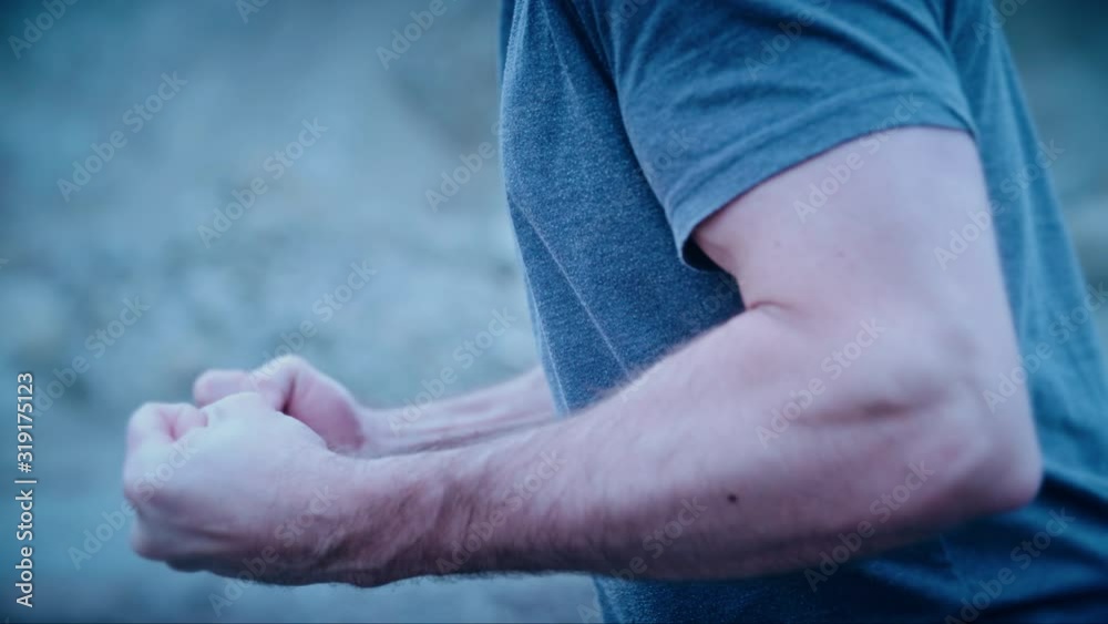 Person flexing biceps muscles powering up close-up 4K. Long shot of ...