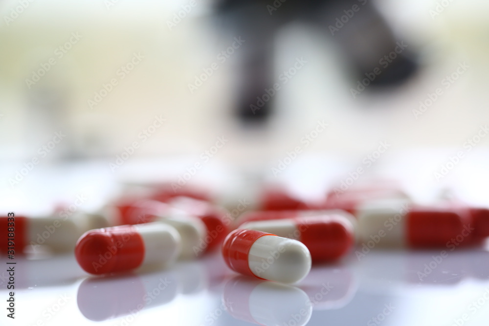 Red tablets scattered on the table of the pharmaceutical laboratory ...