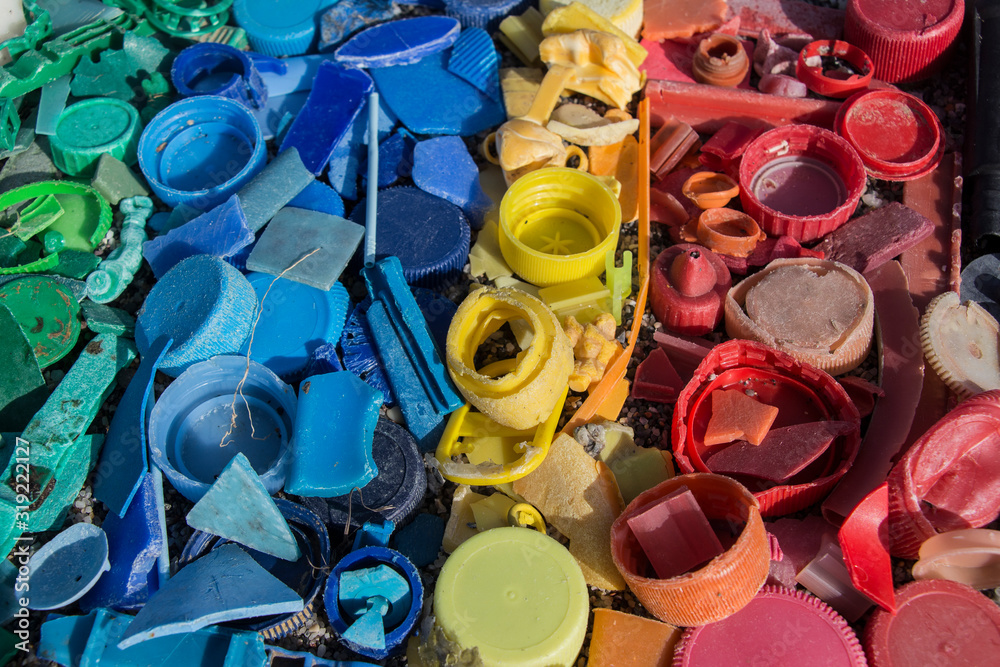 close-up of plastic trash spilled on the beach, dirty sea sandy shore ...
