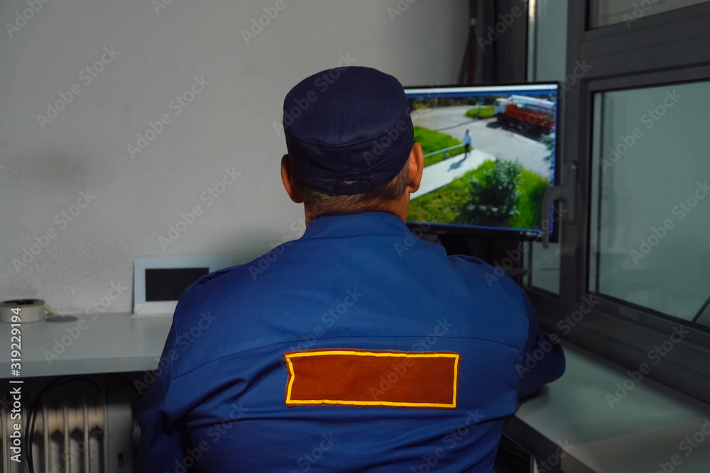 security guard sits at the MONITOR of the CCTV camera. Stock Photo ...