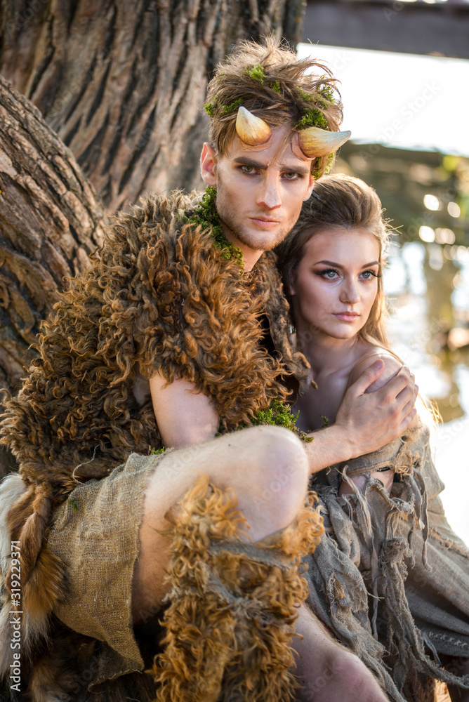 Young couple of elves in love standing in magical forest on the meadow ...