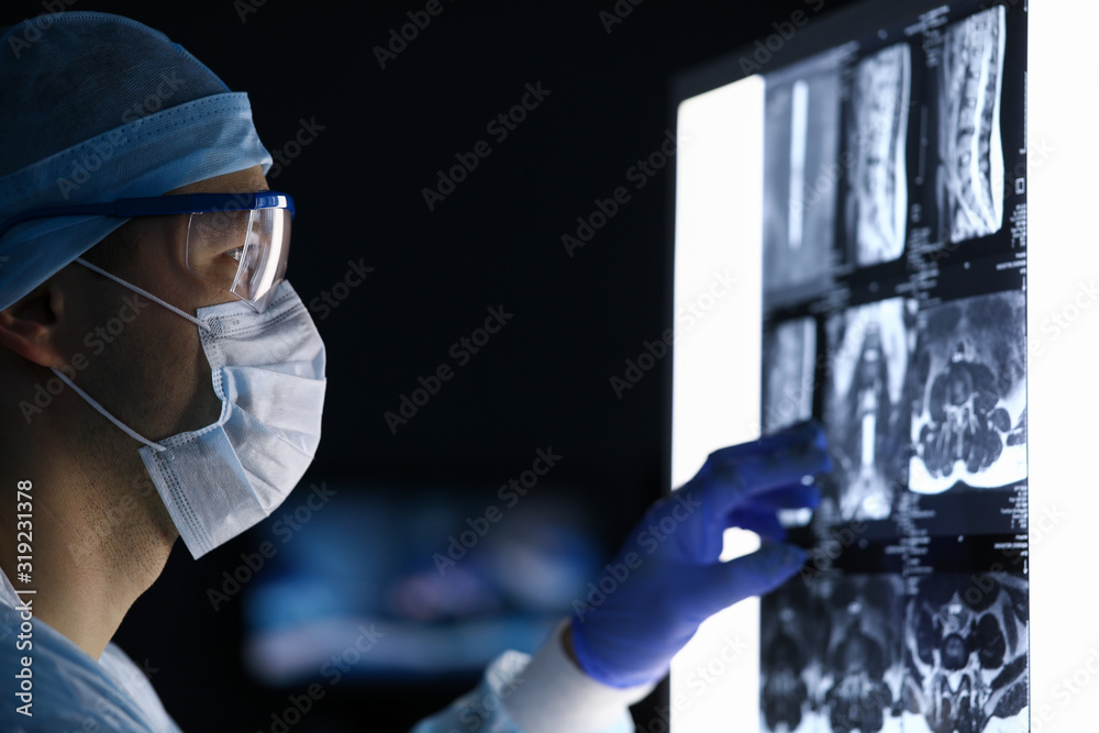Male doctor in surgical clothes looking at vertebral mri scan Stock ...