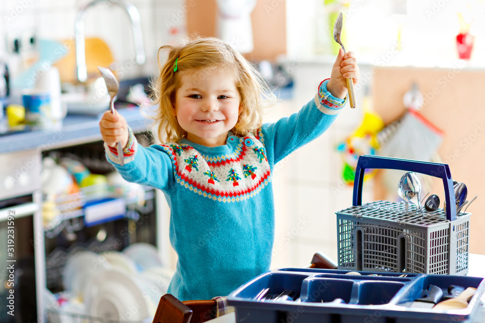 Cute little toddler girl helping in the kitchen with dish washing ...