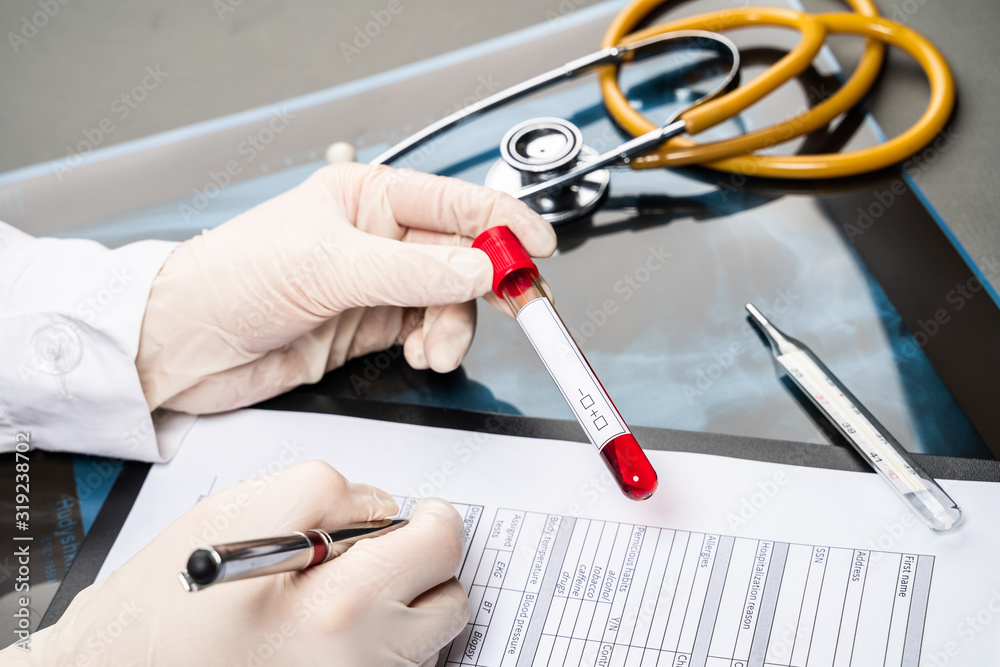 medical doctor 's hand holding blood sample and making notes writing ...