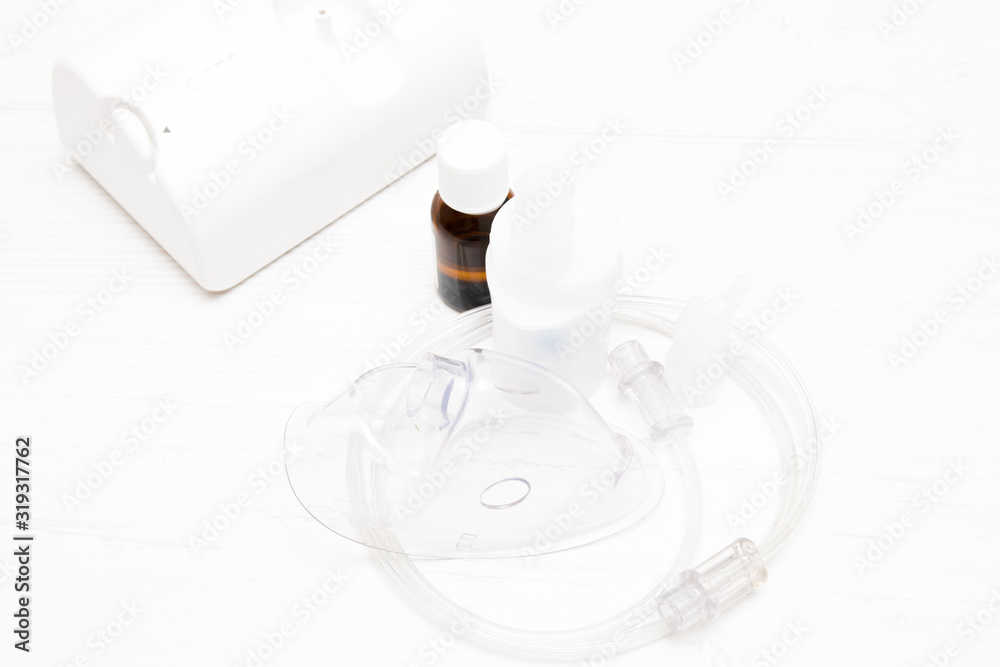 inhaler, tube and mask with a large palat on a light background, copy ...