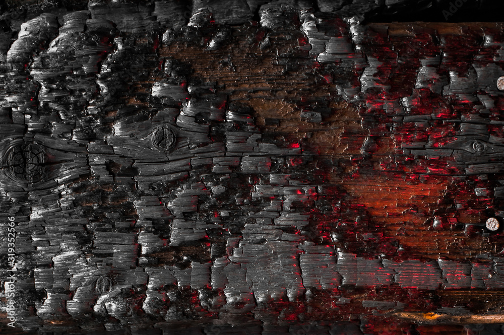 Burnt wooden wall texture colored with red light. Burned scratched ...