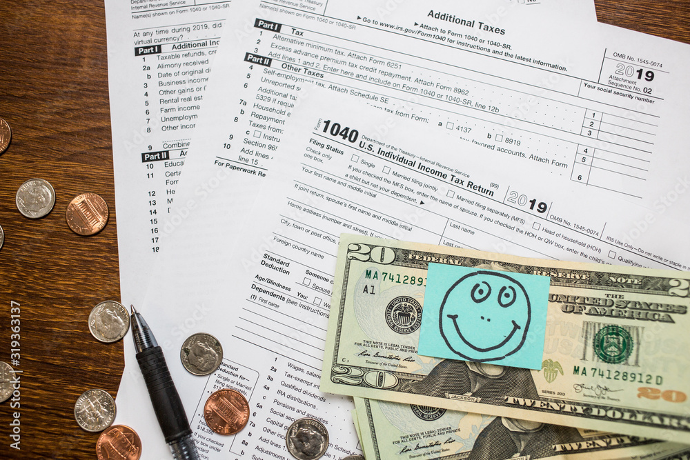 IRS 1040 tax return form with smiley face drawn on a sticker and ...