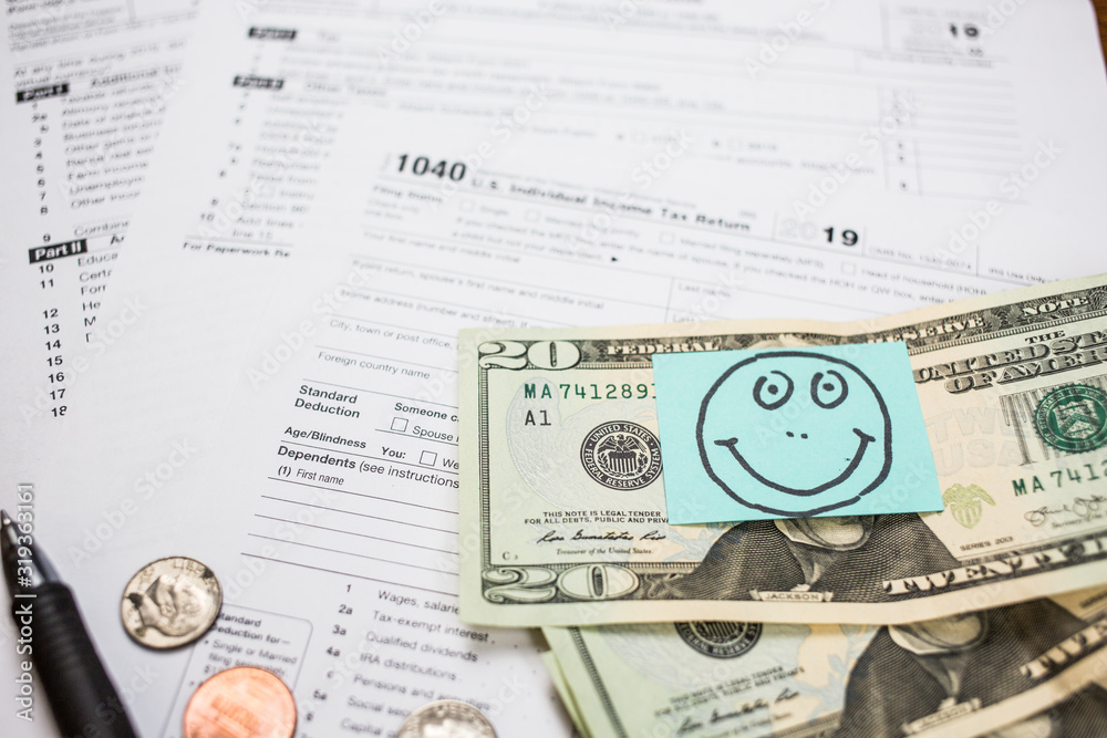 IRS 1040 tax return form with smiley face drawn on a sticker and ...