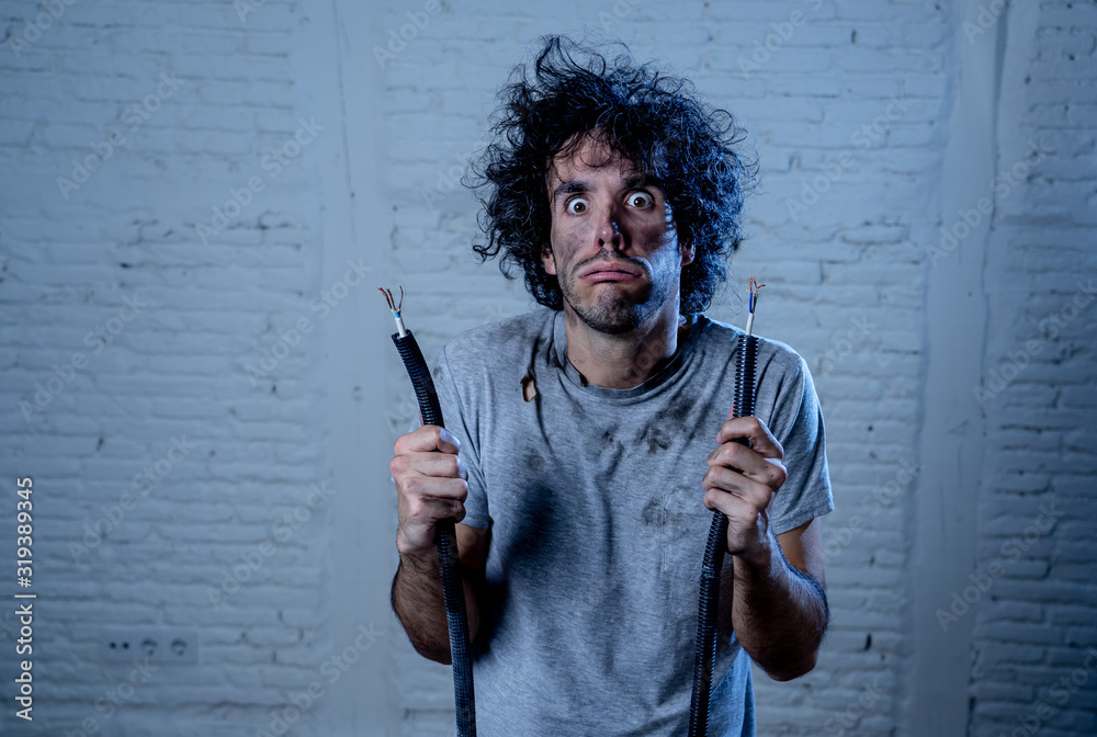 Funny image of man holding electrical cable after getting electric ...