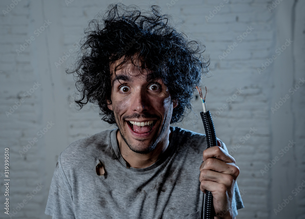Funny image of man holding electrical cable after getting electric ...
