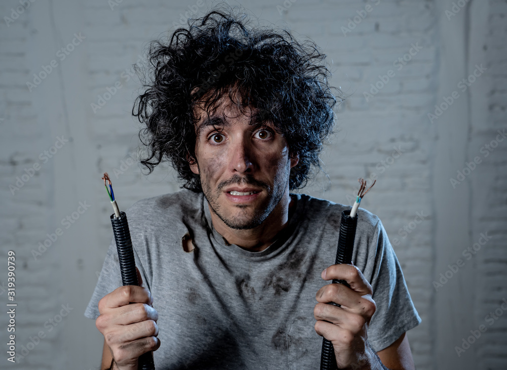 Funny image of man holding electrical cable after getting electric ...