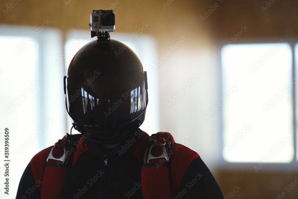 Silhouette of a skydiver close-up in a helmet with a dark tinted glass ...