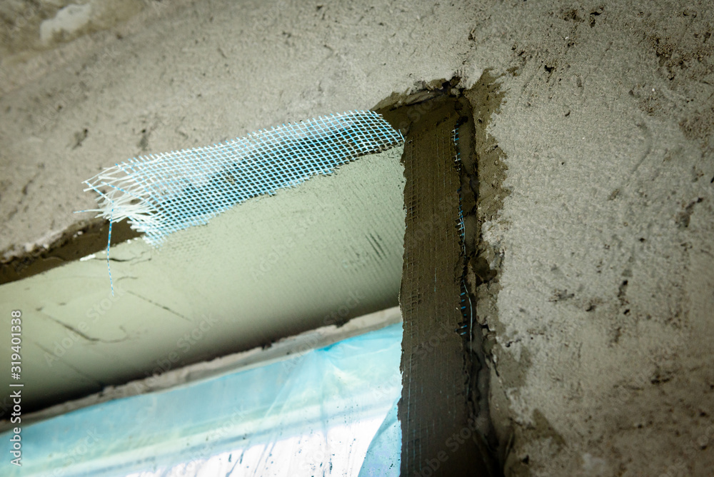 Repair in the slopes of the window. The process of applying a layer of ...