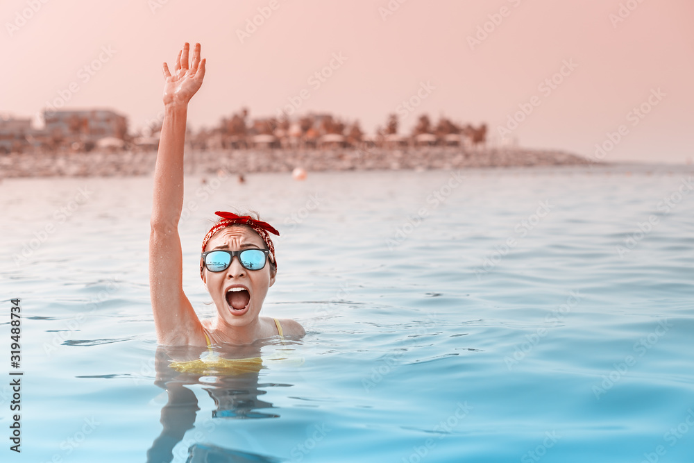 Desperate asian woman swimming in the sea and asking for help, shouts ...