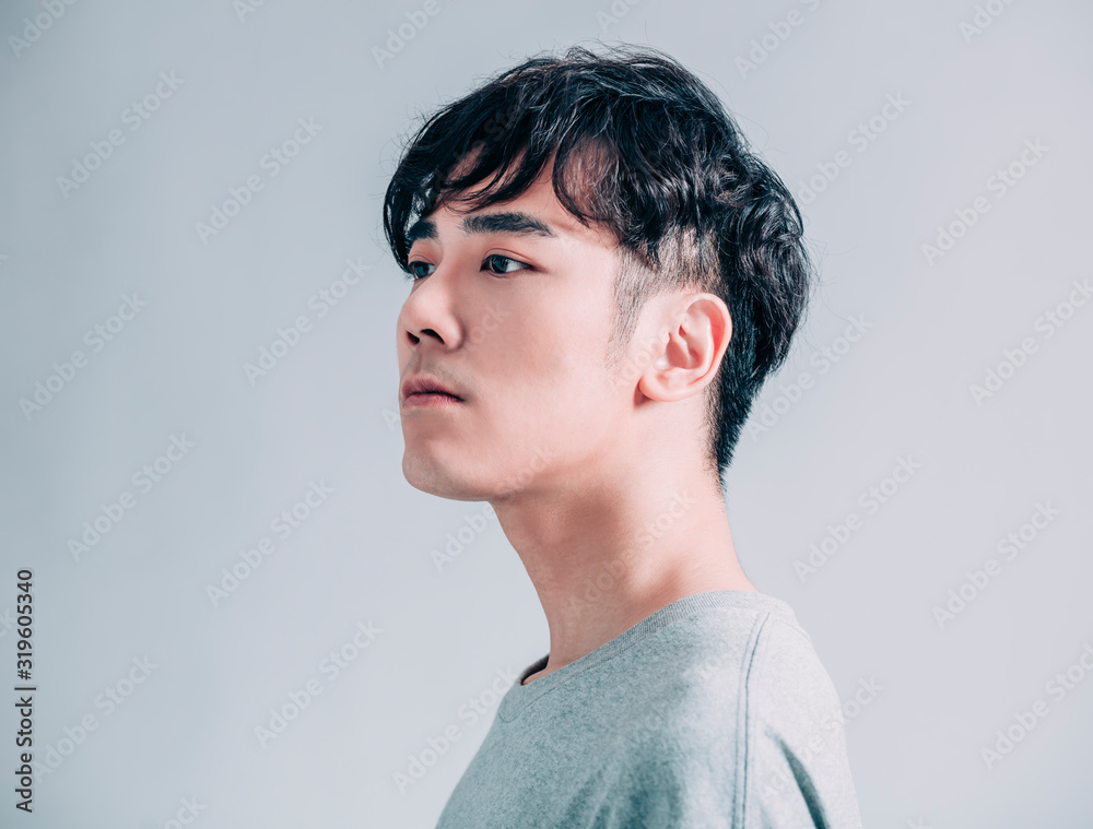 side view of young asian handsome man isolated on gray background Stock ...