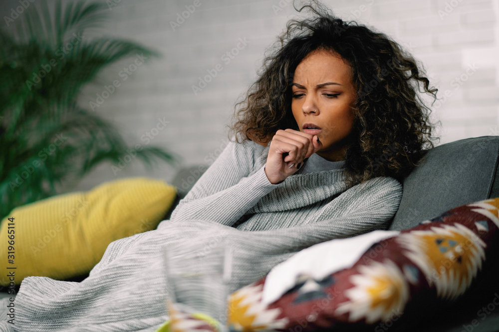 Sick woman at home. Young african woman laying on sofa she is sick ...