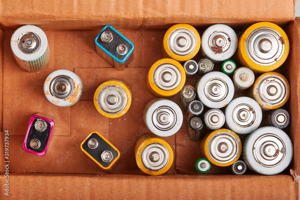 Discharged batteries in cardboard box. Collecting used batteries to ...