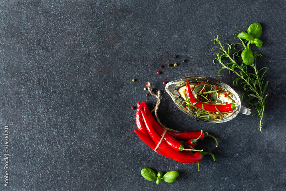 Oil with chili spice and herbs. Fresh chili peppers and rosemary top ...