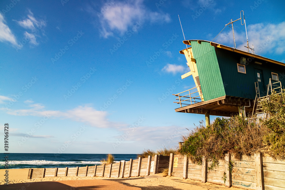 Brightly coloured lifeguard observation tower on sandy beach of Tasman ...