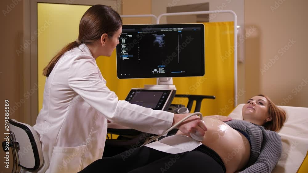 Ultrasound technician communicating with future mother during medical ...