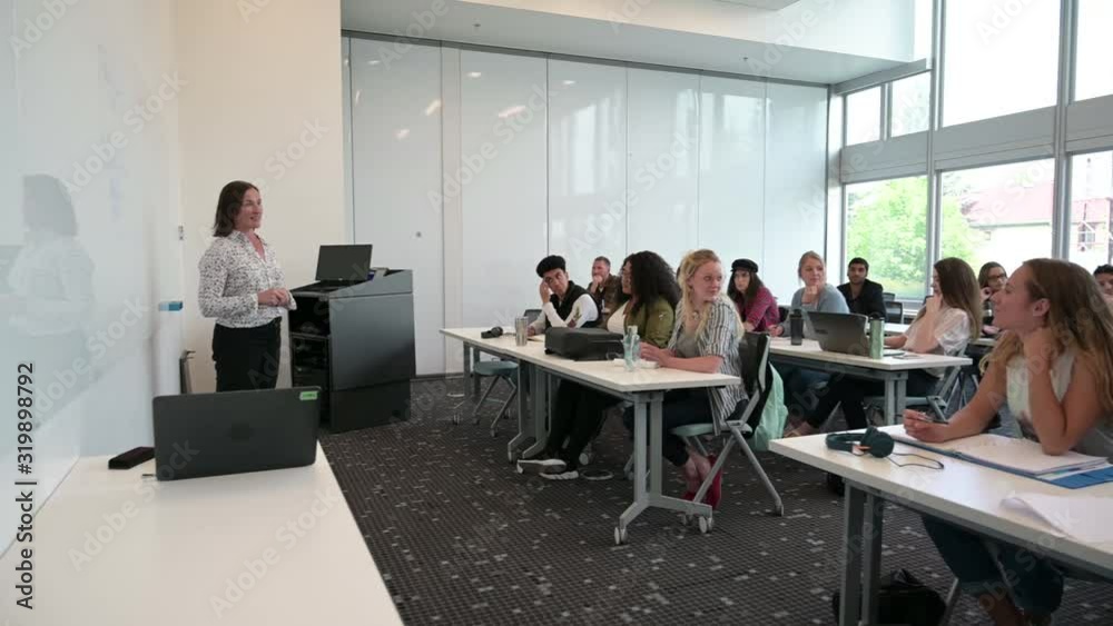 Lecturer presenting to university students in classroom Stock Video ...