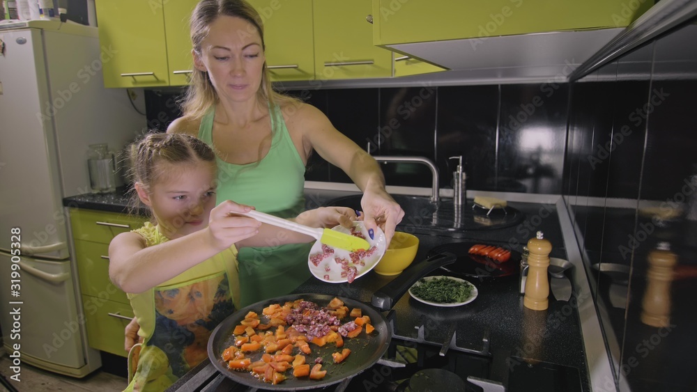 Mother teaching daughter smart girl learning to cook. Young mistress ...