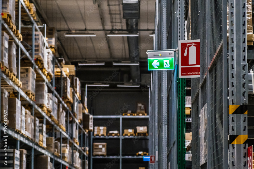 Emergency exit route and Extinguisher sign on top of warehouse. Stock ...