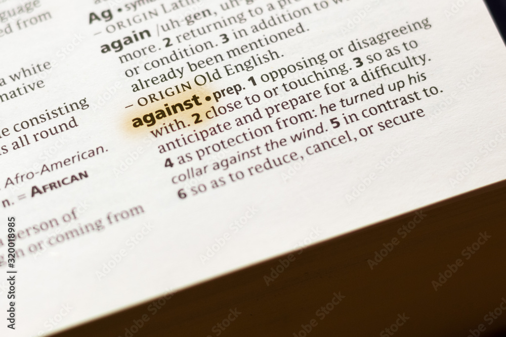 The word or phrase Against in a dictionary. Stock Photo | Adobe Stock
