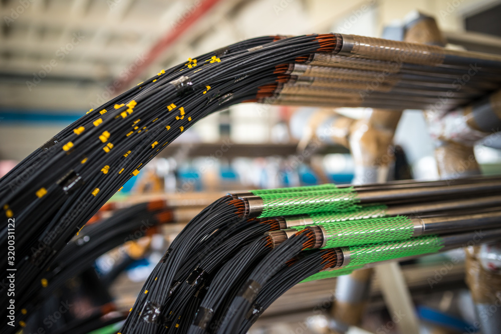 Bundle of wires hangs from pipes Stock Photo | Adobe Stock
