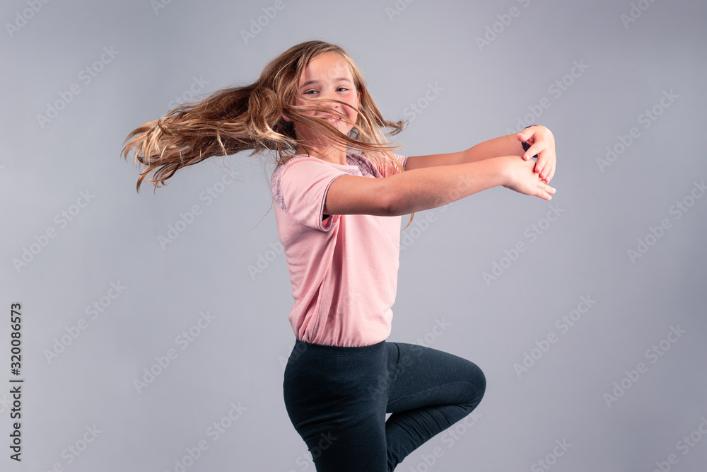 Cheerful 11 year old girl wearing pink t-shirt and black pants with ...