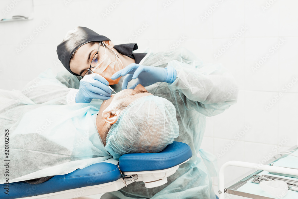 Patient and dentist during implant placement operation. Real operation ...