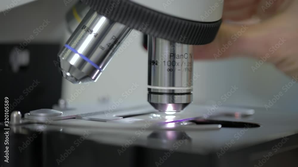 Close-up of lenses of laboratory microscope, coronavirus sample is ...