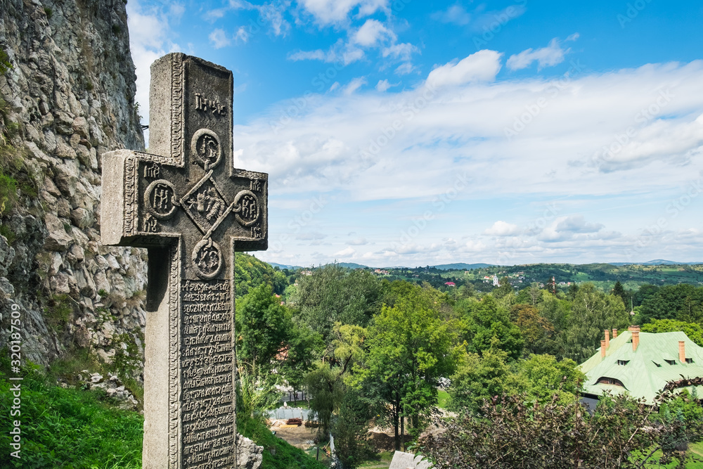 Medieval stone cross with religious symbols at the entrance to the Bran ...