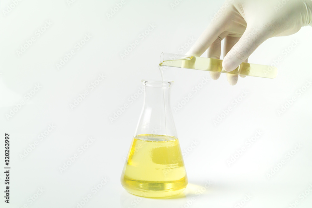 pouring oil from glass tube in laboratory on white background ...