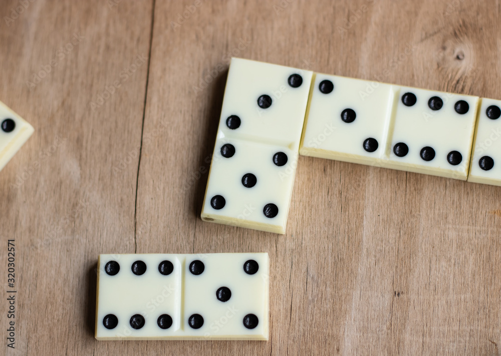 The game of dominoes. Pieces of dominoes on a brown wooden table ...