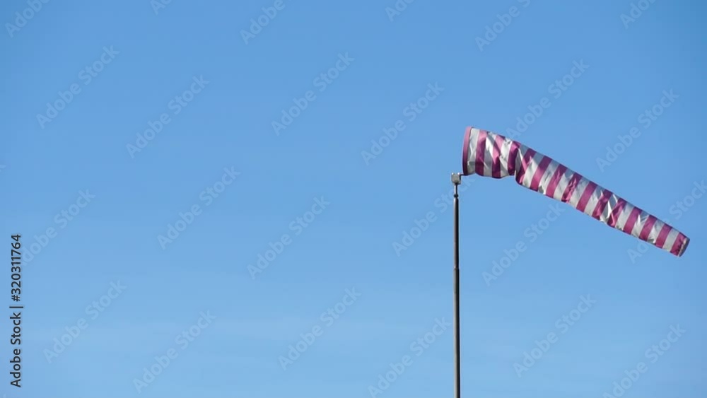 Windsock with red and white stripes show direction of wind blowing and ...