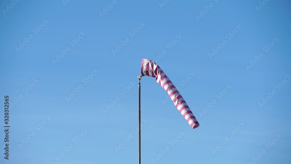 Windsock with red and white stripes show direction of wind blowing and ...
