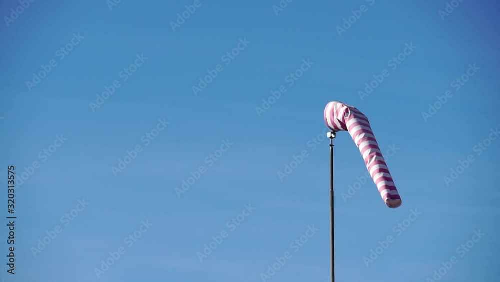 Windsock with red and white stripes show direction of wind blowing and ...